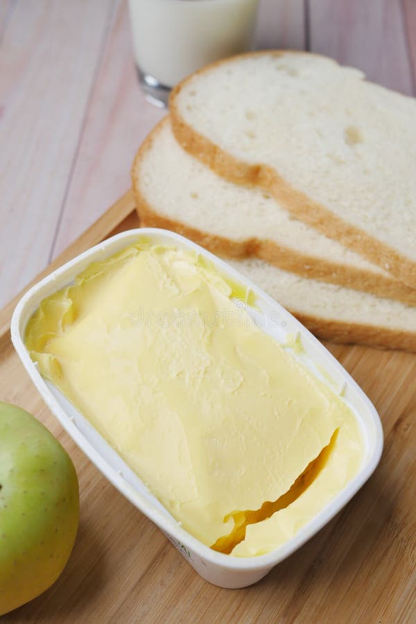 Fresh Butter in a Container with Bread on White Background Stock Image ...