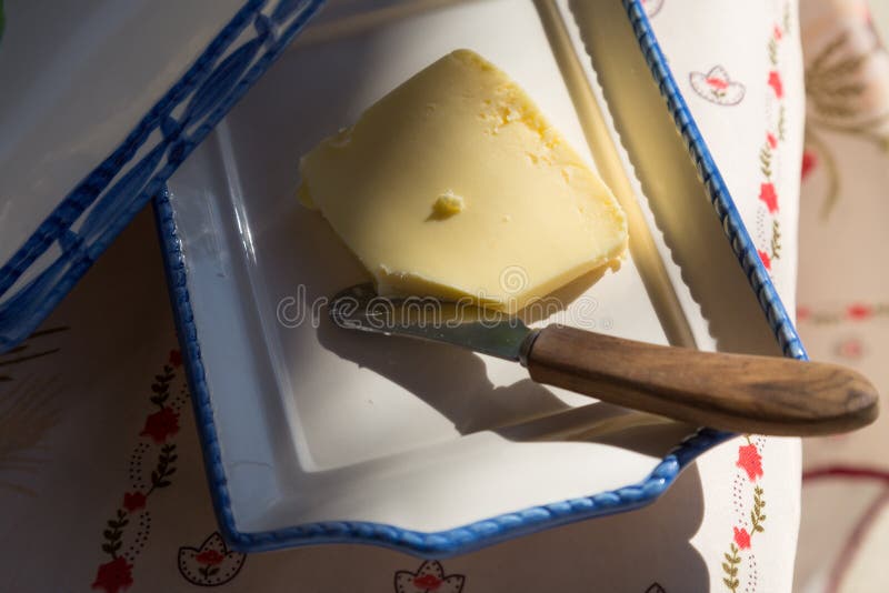 Fresh Butter on Plate with Wooden Knife and Table Cloth Stock Photo ...