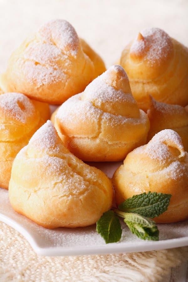Fresh Eclairs with Powdered Sugar and Mint Close Up. Vertical Stock ...