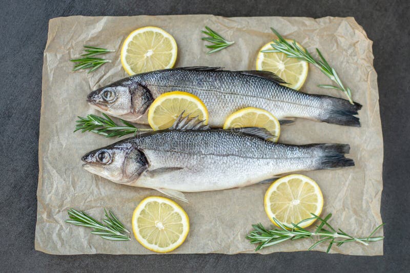 Fresh Fish with Spices and Herbs on Table in Kitchen. Fresh Sea Bass ...