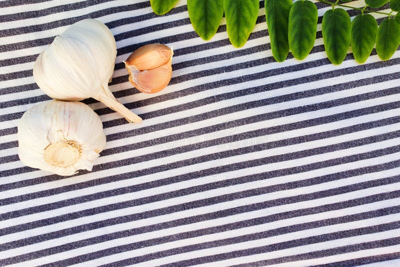 Fresh Garlic and Green Leaves on Striped Textile Background Stock Photo ...