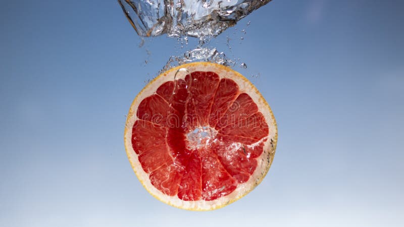Fresh Grapefruit with Water Splash on Blue Background Close Up Stock ...