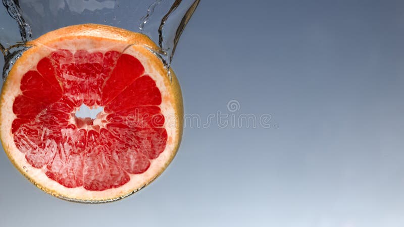 Fresh Grapefruit with Water Splash on Blue Background Close Up Stock ...