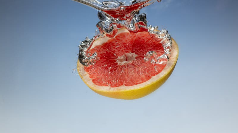 Fresh Grapefruit with Water Splash on Blue Background Close Up Stock ...