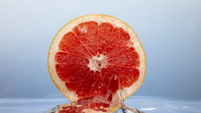 Fresh Grapefruit with Water Splash on Blue Background Close Up Stock ...