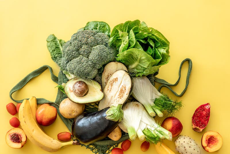 Fresh Green Vegetables and Fruits in a Green String Bag on a Yellow ...