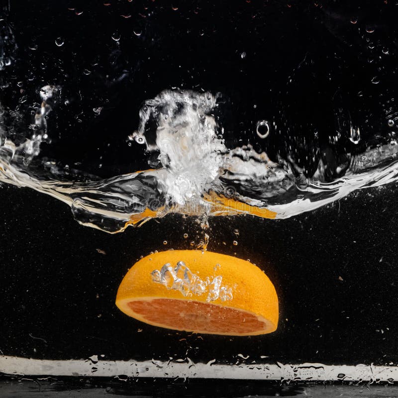 Fresh Half Orange, Slices Falling into the Water with a Splash of Water ...