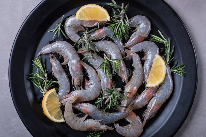 Fresh King Prawns on a Black Plate with Lemon and Basil. Stock Image ...