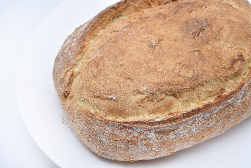 A Fresh Loaf of Bread on a Plate. a Piece of Delicious Bread Stock ...