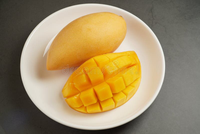 Fresh Mango on White Plate and Black Pattern Background Stock Photo ...