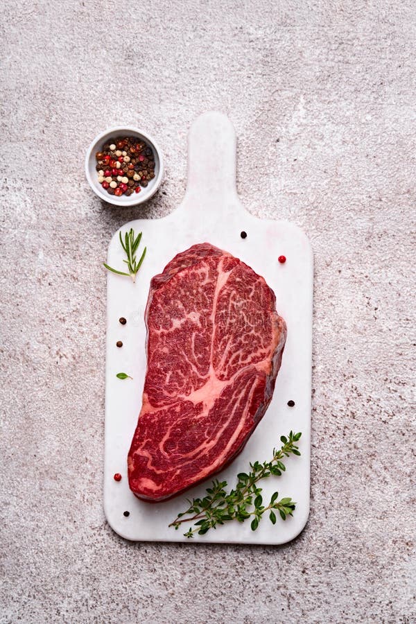 Fresh Marbled Beef Rib Eye Steak and Spices on Grey Stone Background ...