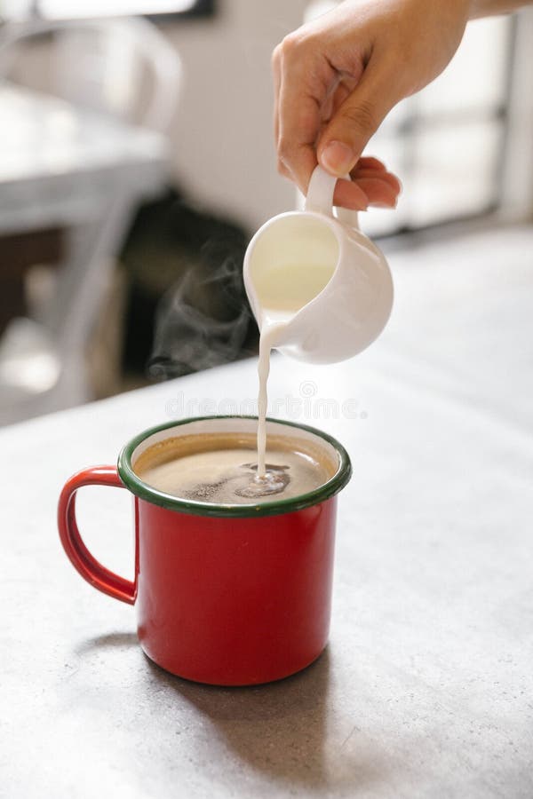 Fresh Milk Pouring in Hot Coffee in Red Cup with Steam Stock Photo ...