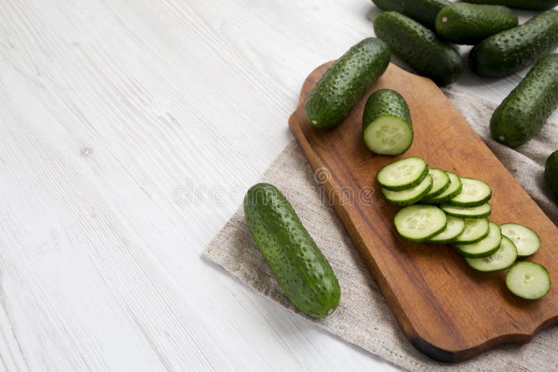 Fresh Mini Baby Cucumbers on a Rustic Wooden Board, Low Angle View ...