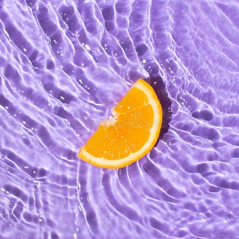 Fresh Orange Fruit Slice Floating in a Purple Wave Water. Minimal ...
