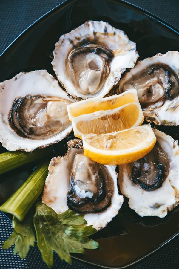 Fresh Oysters with Lemon and Celery on a Plate Stock Photo - Image of ...