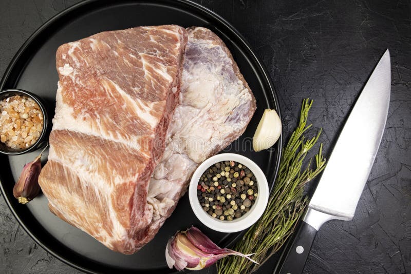 Fresh Pork Ribs on a Black Cutting Table with Spices and Aromatic Herbs ...