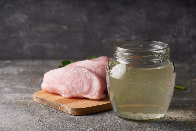 Fresh Poultry Broth in a Glass Jar on a Table with Vegetables and ...