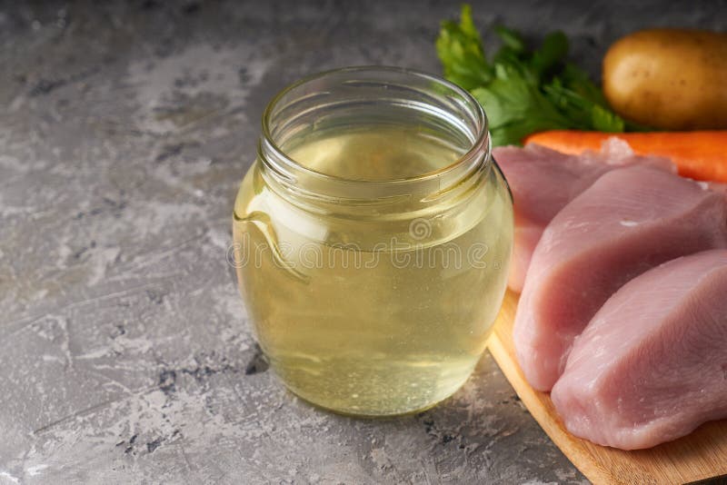 Fresh Poultry Broth in a Glass Jar on a Table with Vegetables and ...