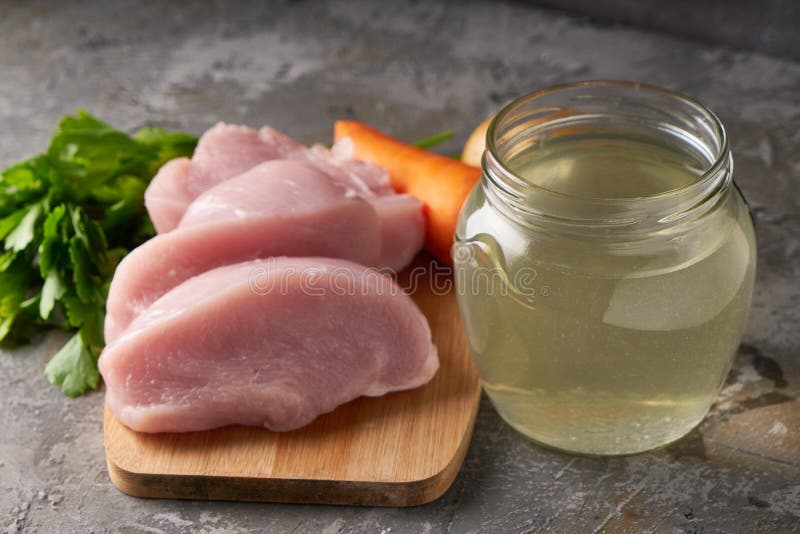 Fresh Poultry Broth in a Glass Jar on a Table with Vegetables and ...