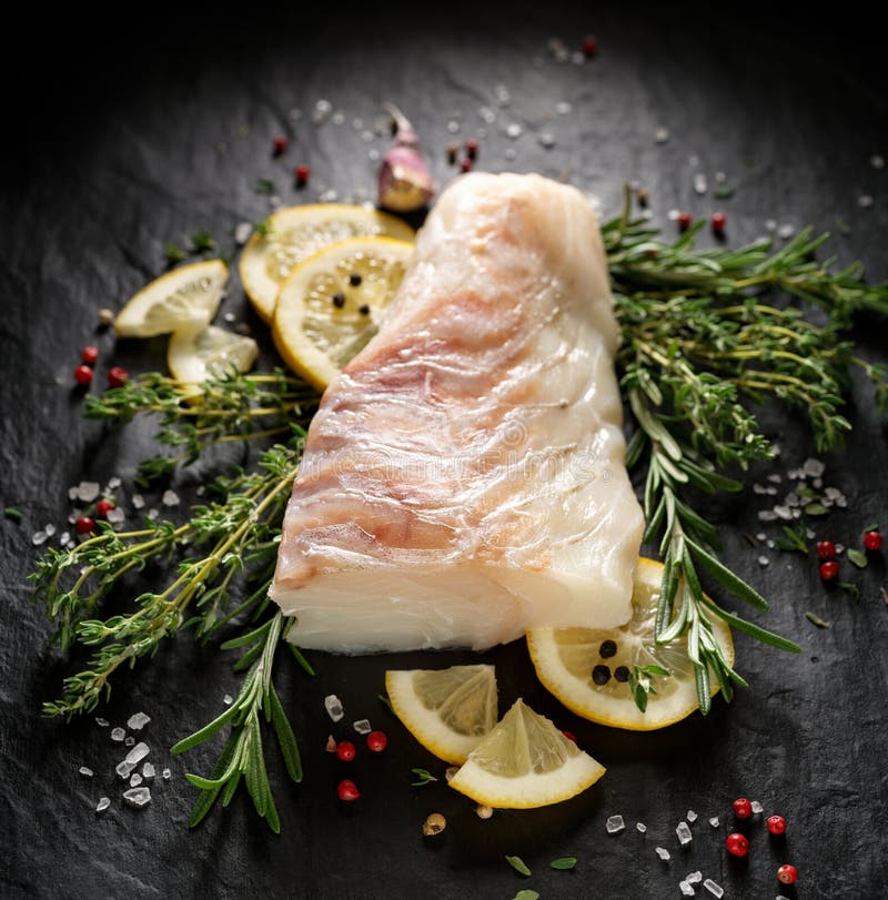 Fresh Raw Cod Fillet with Addition of Herbs and Lemon Slices on Black ...