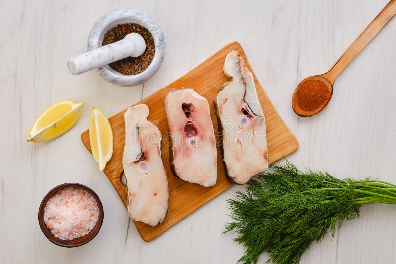 Fresh Raw Cod Steak on Wooden Cutting Board with Spice Stock Photo ...
