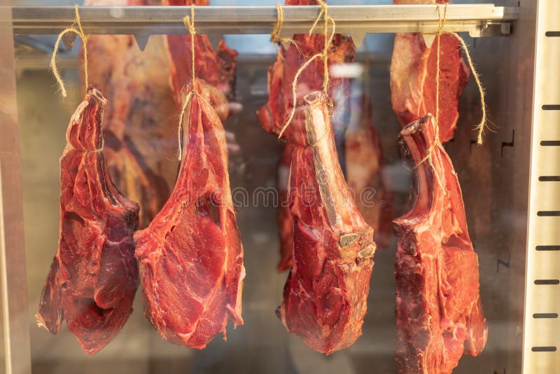 Fresh Raw Meat on the Bone Hanging from a Rope in a Shop Window Stock ...