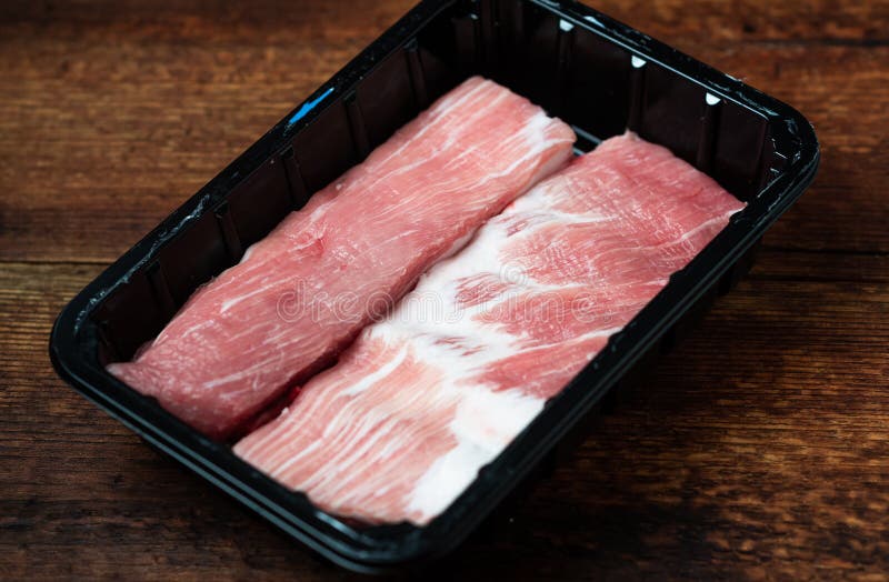 Fresh Raw Meat and Pork Ribs in Plastic Packaging on a Wooden ...