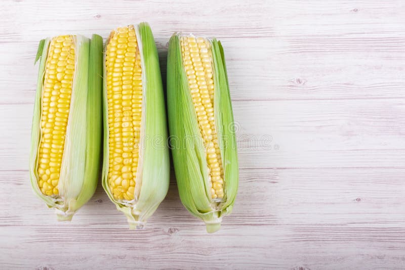 Fresh Raw Sweet Corn on the Cob Kernels Over Wooden Background Stock ...