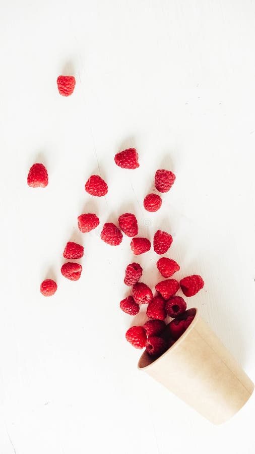 Fresh Red Raspberries in a Paper Cup on a White Table Background Stock ...