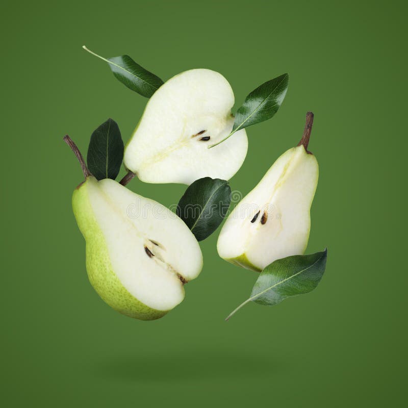 Fresh Ripe Cut Pears and Leaves Falling on Green Background Stock ...