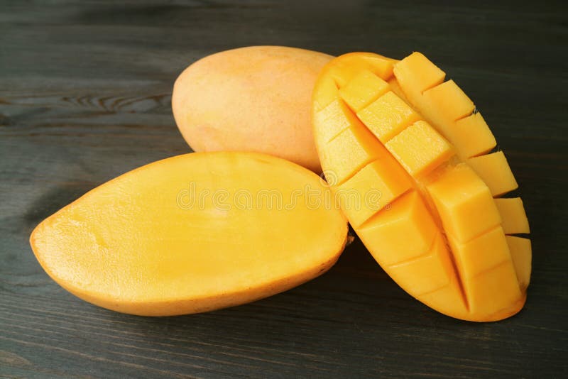 Fresh Mango Cut in Half and Crosswise Cut with a Whole Fruit on Black ...