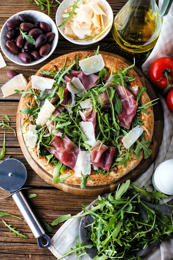 Fresh Rucola Pizza with Parma Ham on Wooden Cuting Board. Stock Photo ...