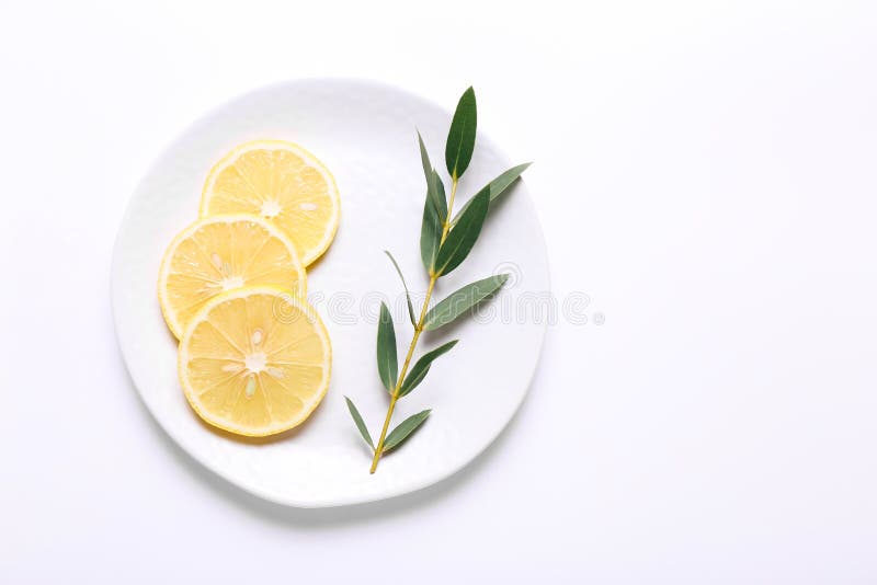 Fresh Sliced Lemon on Plate with Green Leaves on White Background Stock ...