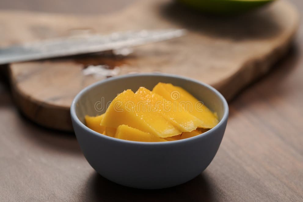 Fresh Sliced Mango in a Ceramic Bowl on Walnut Table Stock Photo ...