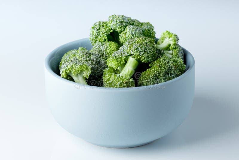 Fresh Slices of Broccoli in a Light Blue and Dull Ceramic Bowl on White ...