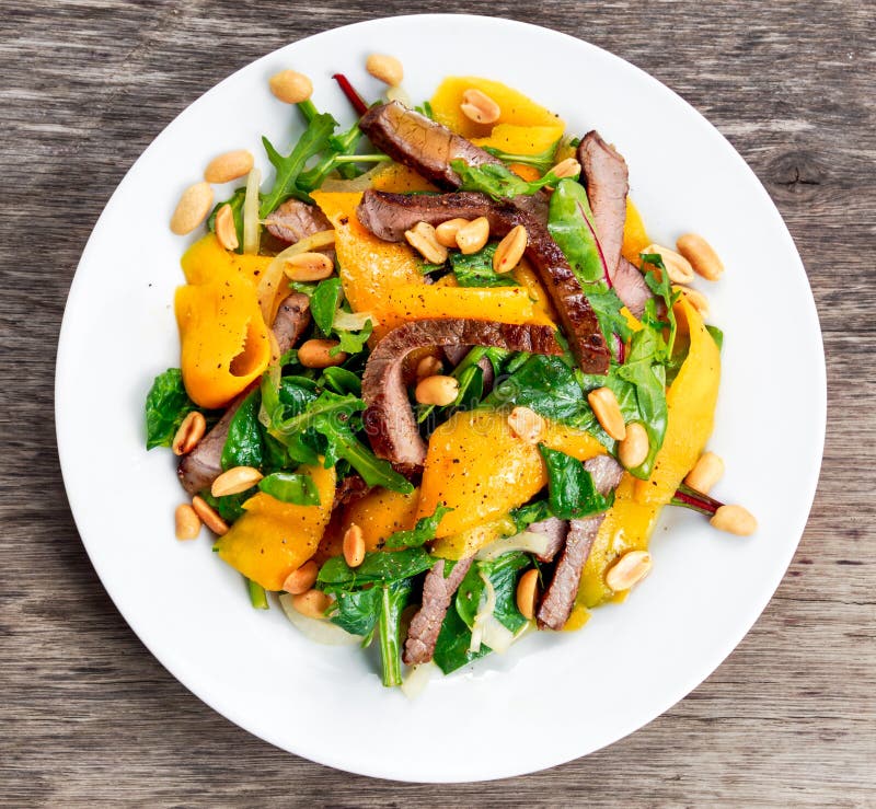 Fresh Tasty Mango, Beef Salad with Vegetables and Nuts. Stock Photo ...