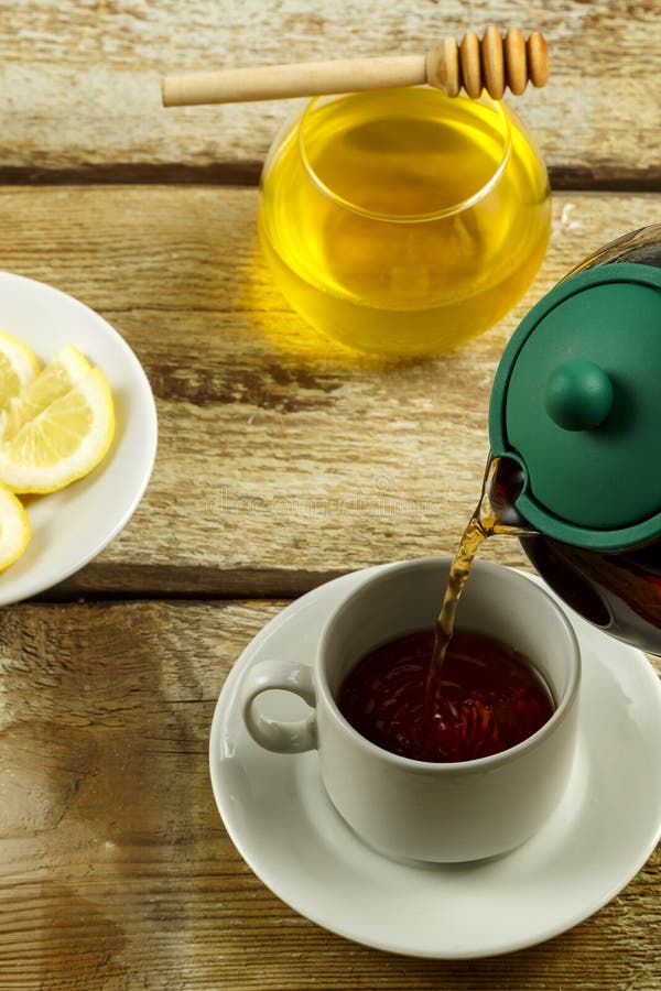 Fresh Tea from the Teapot is Poured into a White Cup. Stock Image ...