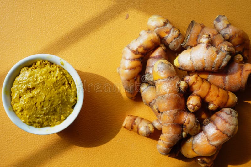 Fresh Turmeric Roots Alongside Turmeric Paste on Table Stock Image ...