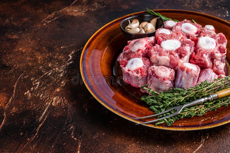 Fresh Uncooked Beef Oxtail Cut Meat on Rustic Plate with Herbs. Dark ...
