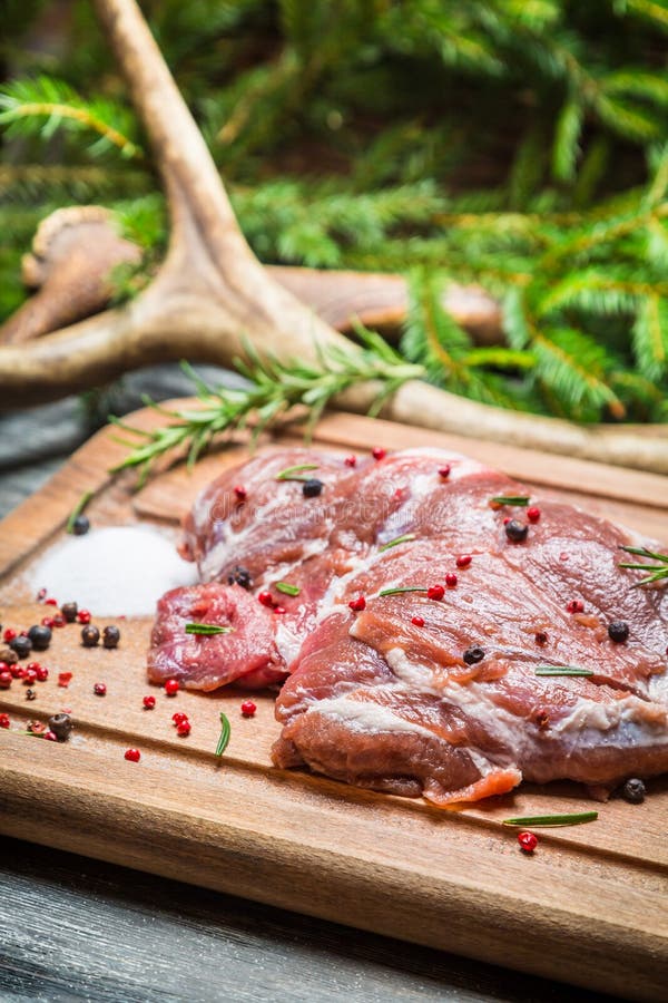 Fresh Venison on the Background of Antlers and Spruce Stock Photo ...