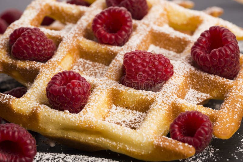 Fresh Waffles Garnished with Powdered Sugar and Raspberries Stock Photo ...