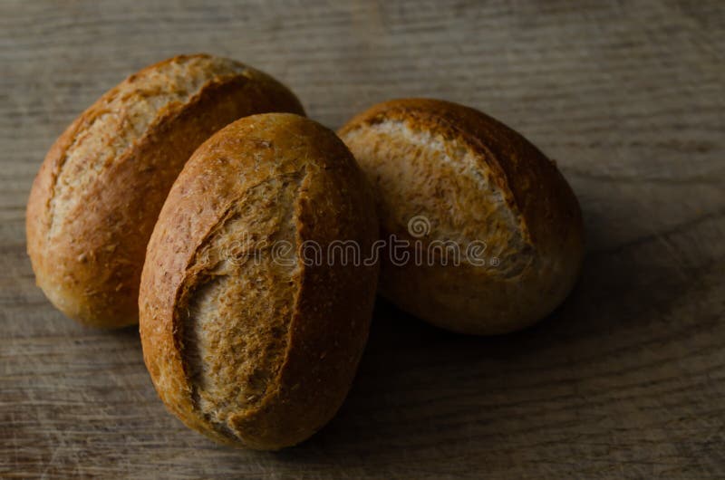 Freshly Baked Buns on an Old Oak Board Stock Photo - Image of loaf ...