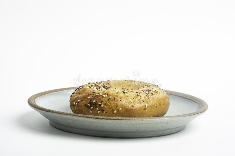 A Freshly Baked Single Bagel on a Ceramic Plate Stock Image - Image of ...