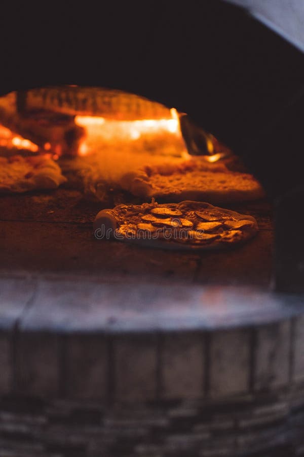A Pizza Sitting Inside of a Brick Oven, in a Pizza Kitchen Stock Image ...