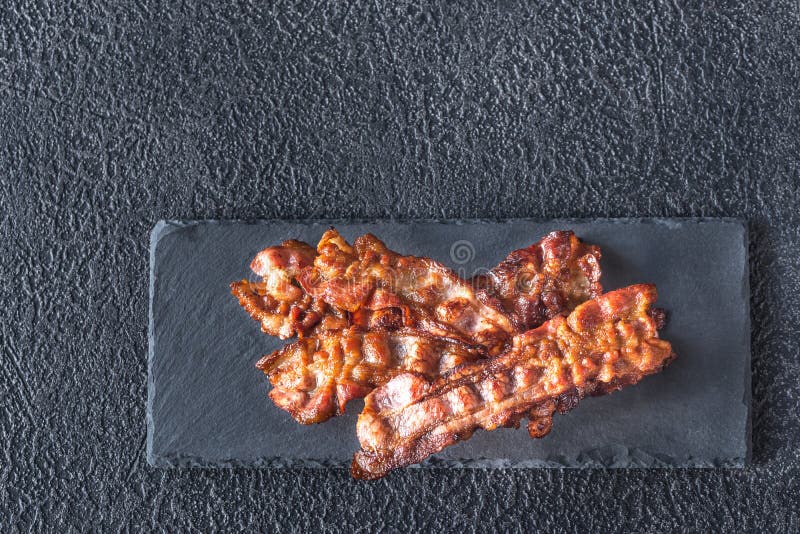 Fried Bacon Strips on the Stone Dark Board Stock Photo - Image of pile ...