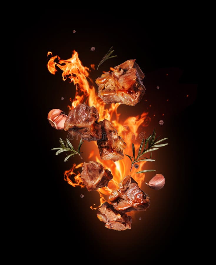 Fried Beef Steaks with Rosemary and Garlic on Fire Close Up in the Dark ...