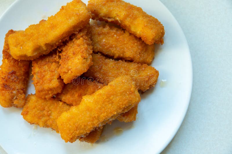 Fried Brown Fish Fingers on a White Plate Stock Photo - Image of ...