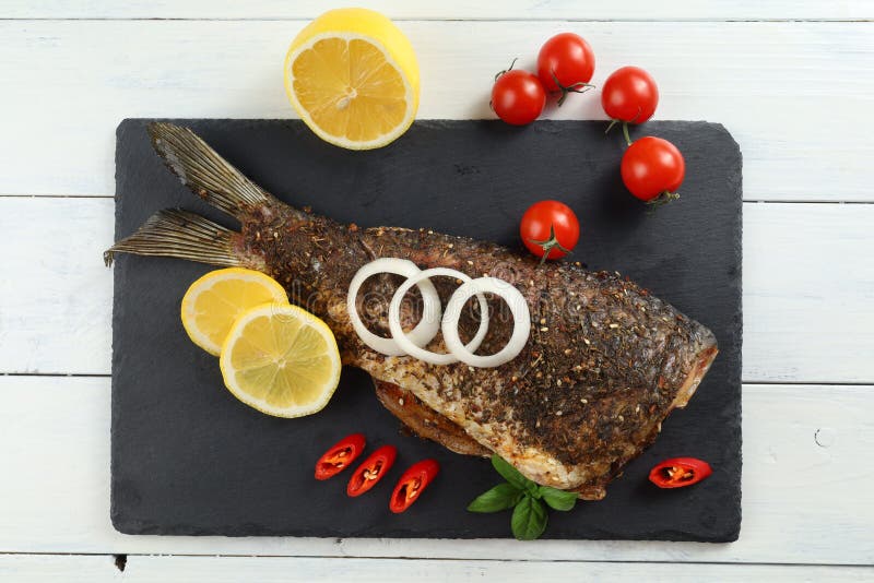 Fried Carp Fish on the Table. Baked Fish with Vegetables Stock Image ...