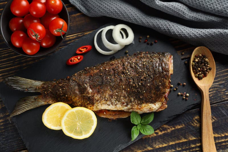 Fried Carp Fish with Vegetables, Tomatoes and Lemon Stock Photo - Image ...