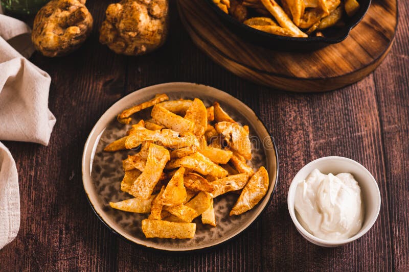 Fried Celery Root on a Plate and Sauce in a Bowl on the Table Stock ...